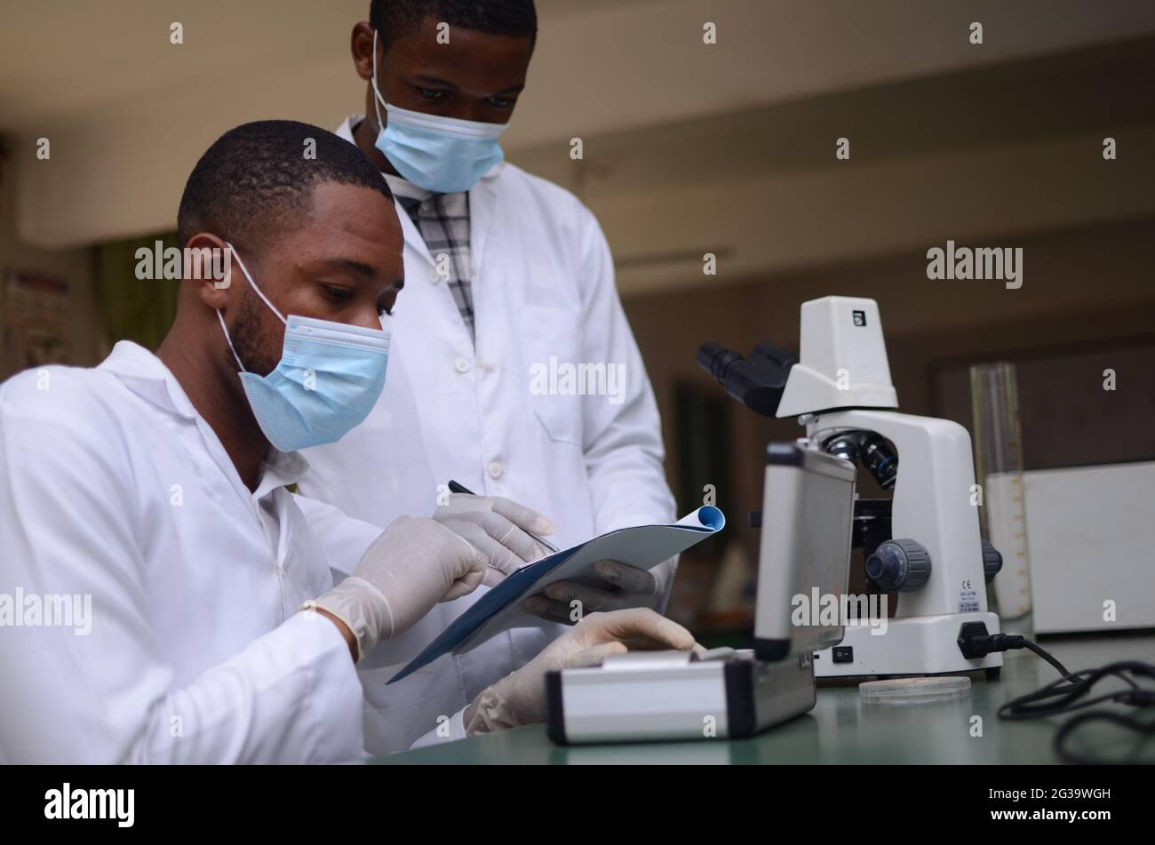 Scientist microbiologists with uniforms working with test tubes and a ...