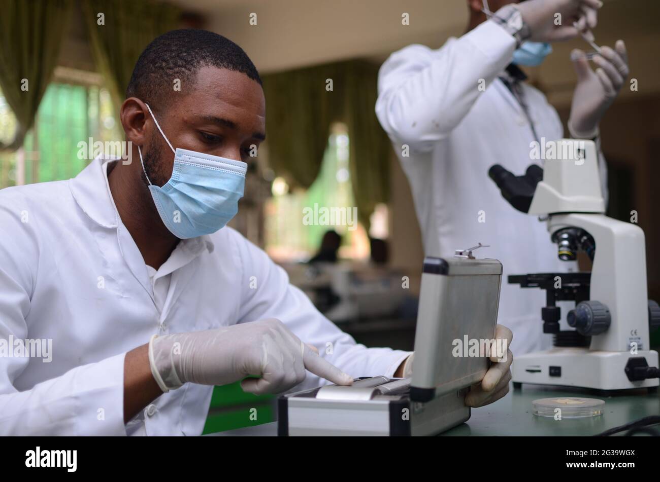 Scientist microbiologists with uniforms working with test tubes and a ...