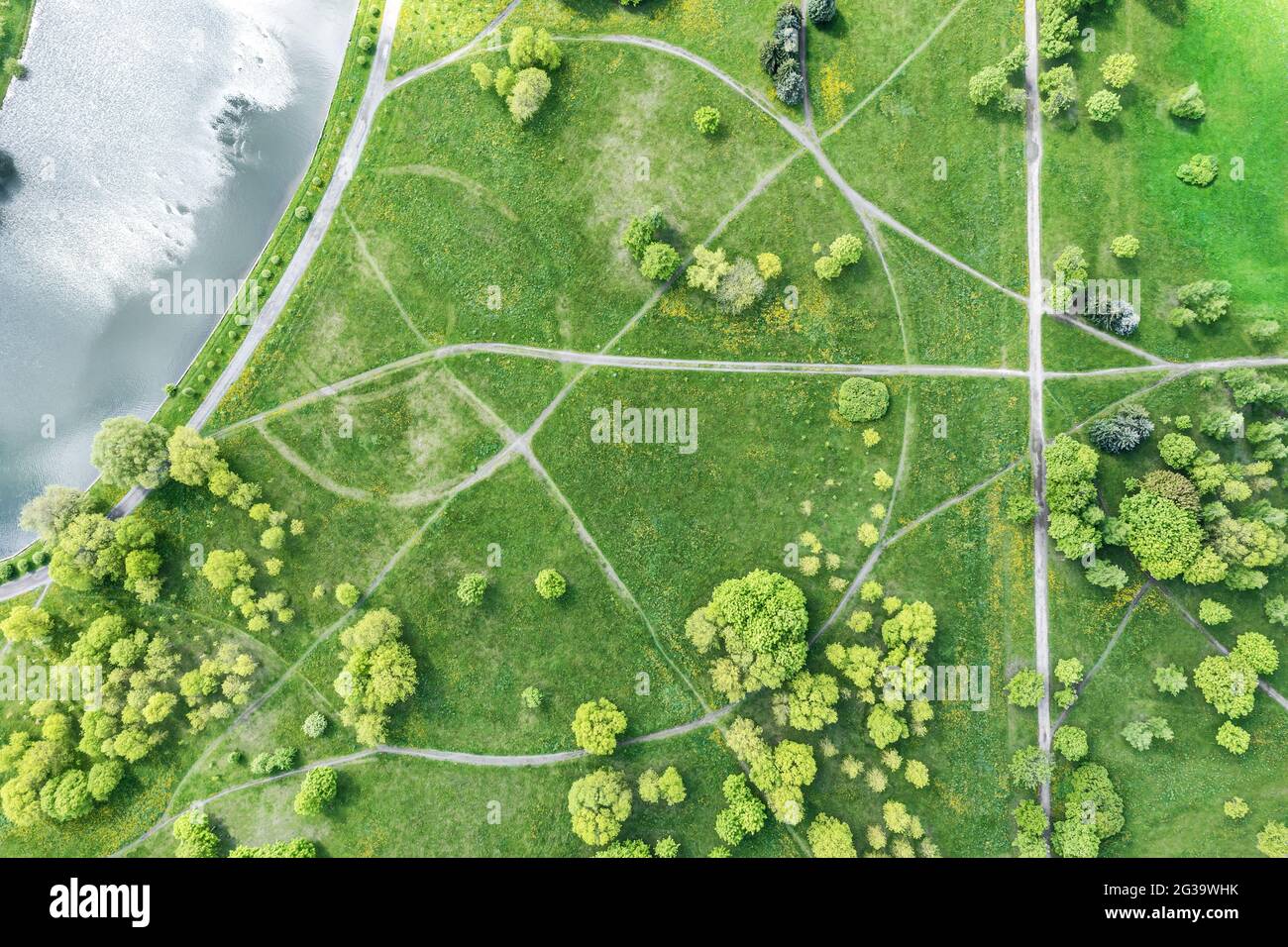 aerial top view of public park with river and footpaths on green lawn ...