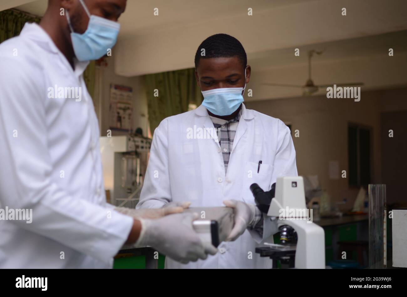 Scientist microbiologists with uniforms working with test tubes and a ...