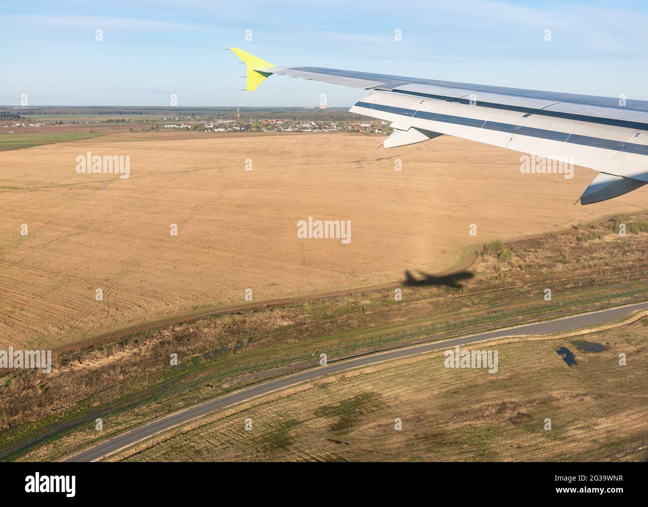 View of airplane wing, Shadow of the plane on the ground during landing ...