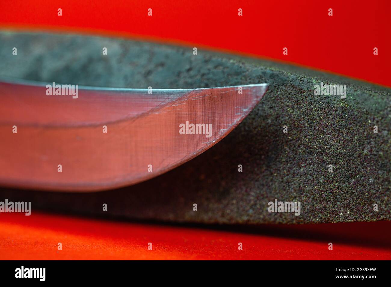knife sharpening and stone for sharpening knives on a red background ...