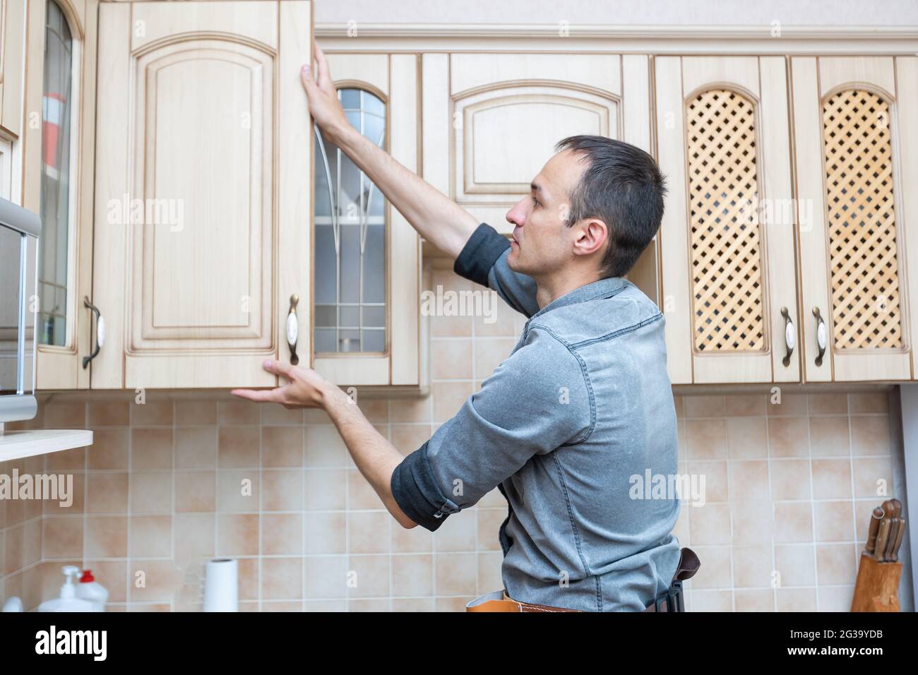 kitchen installation. Worker assembling furniture Stock Photo - Alamy