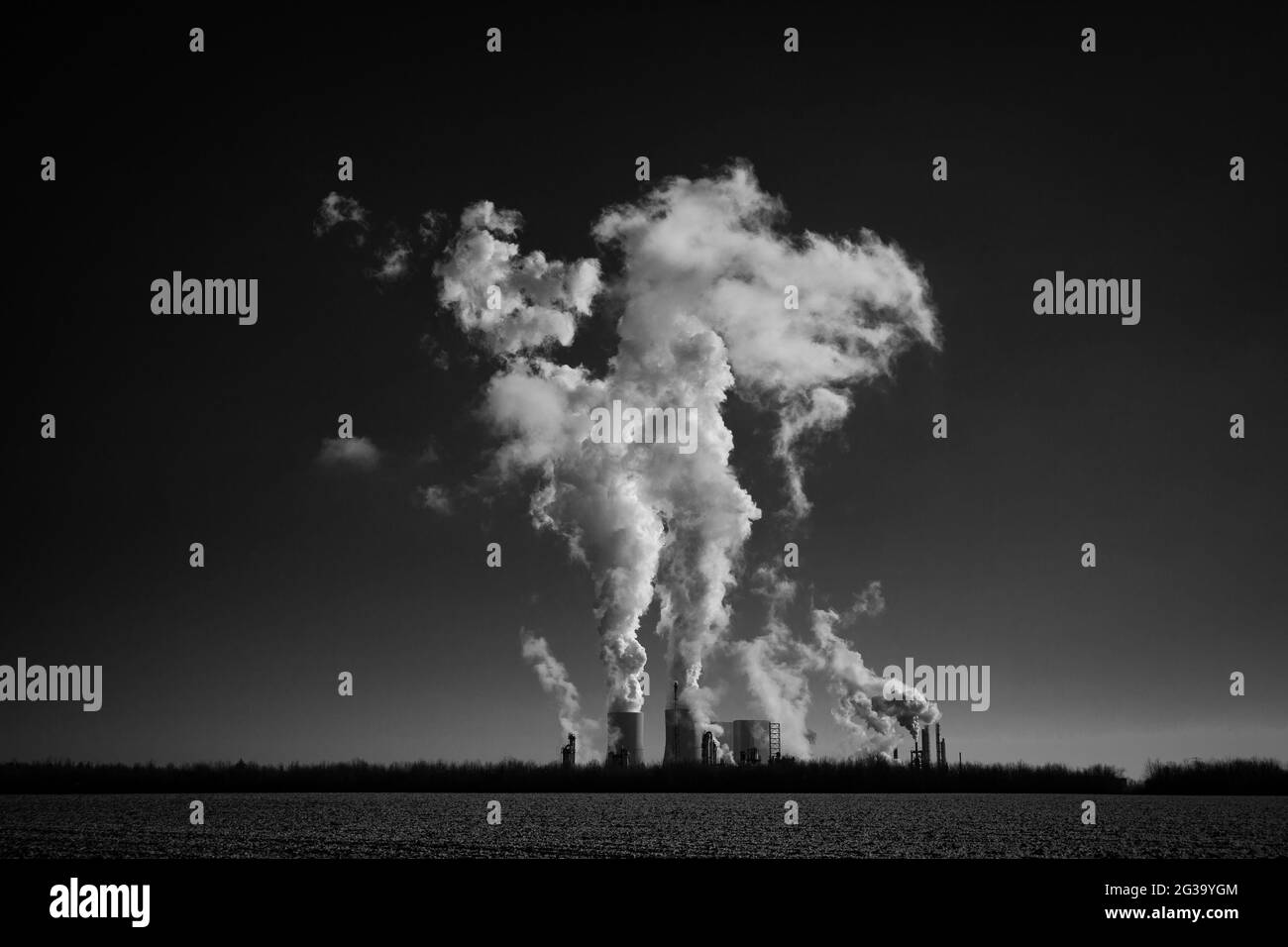 Heavy smoke coming out of a big factory in a field - concept of ...