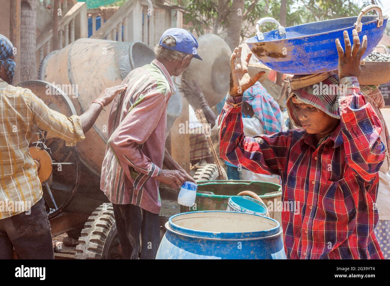 Female Indian manual labour workers carrying heavy loads on their heads ...