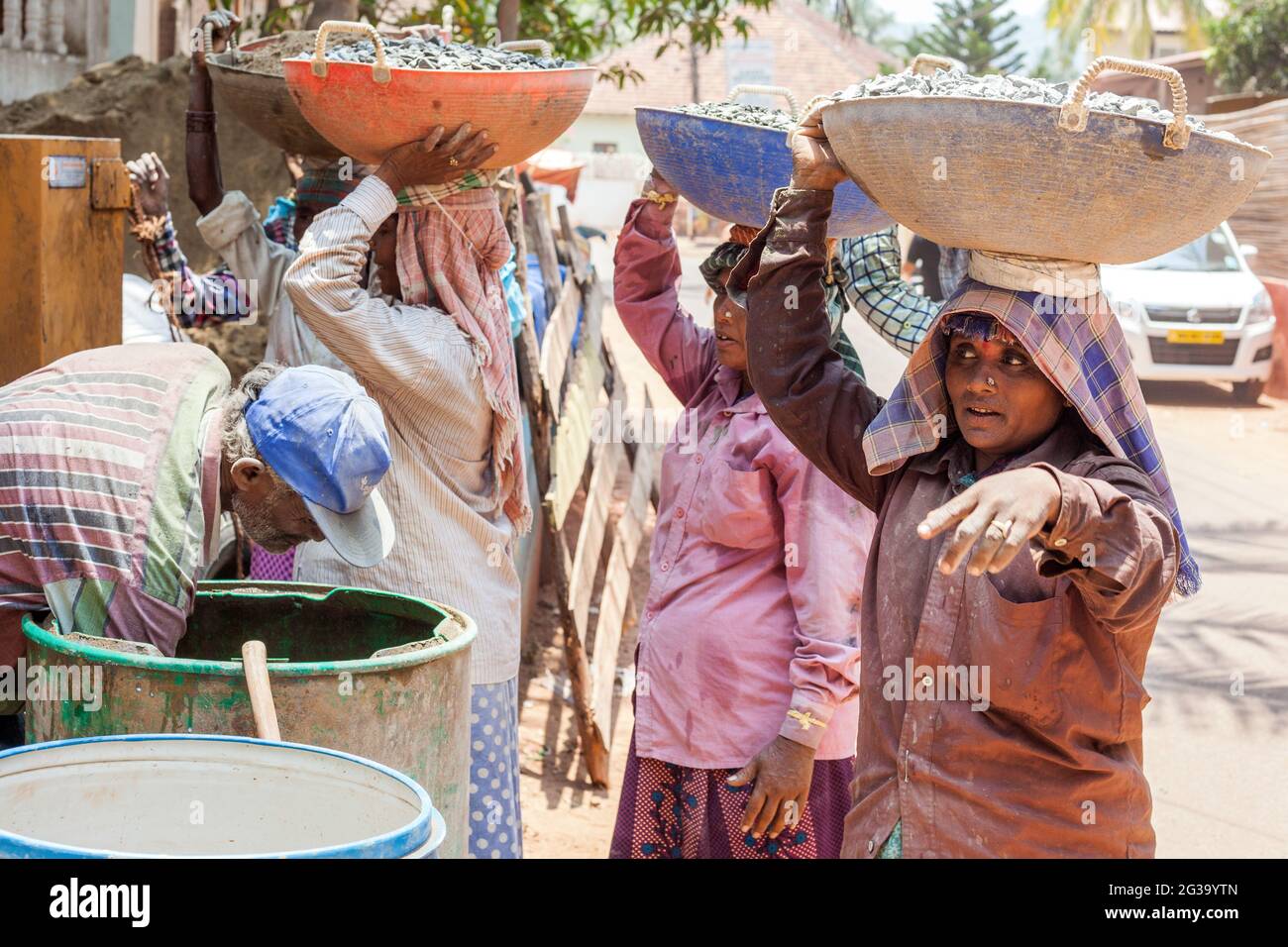 Female Indian manual labour workers carrying heavy loads on their heads ...