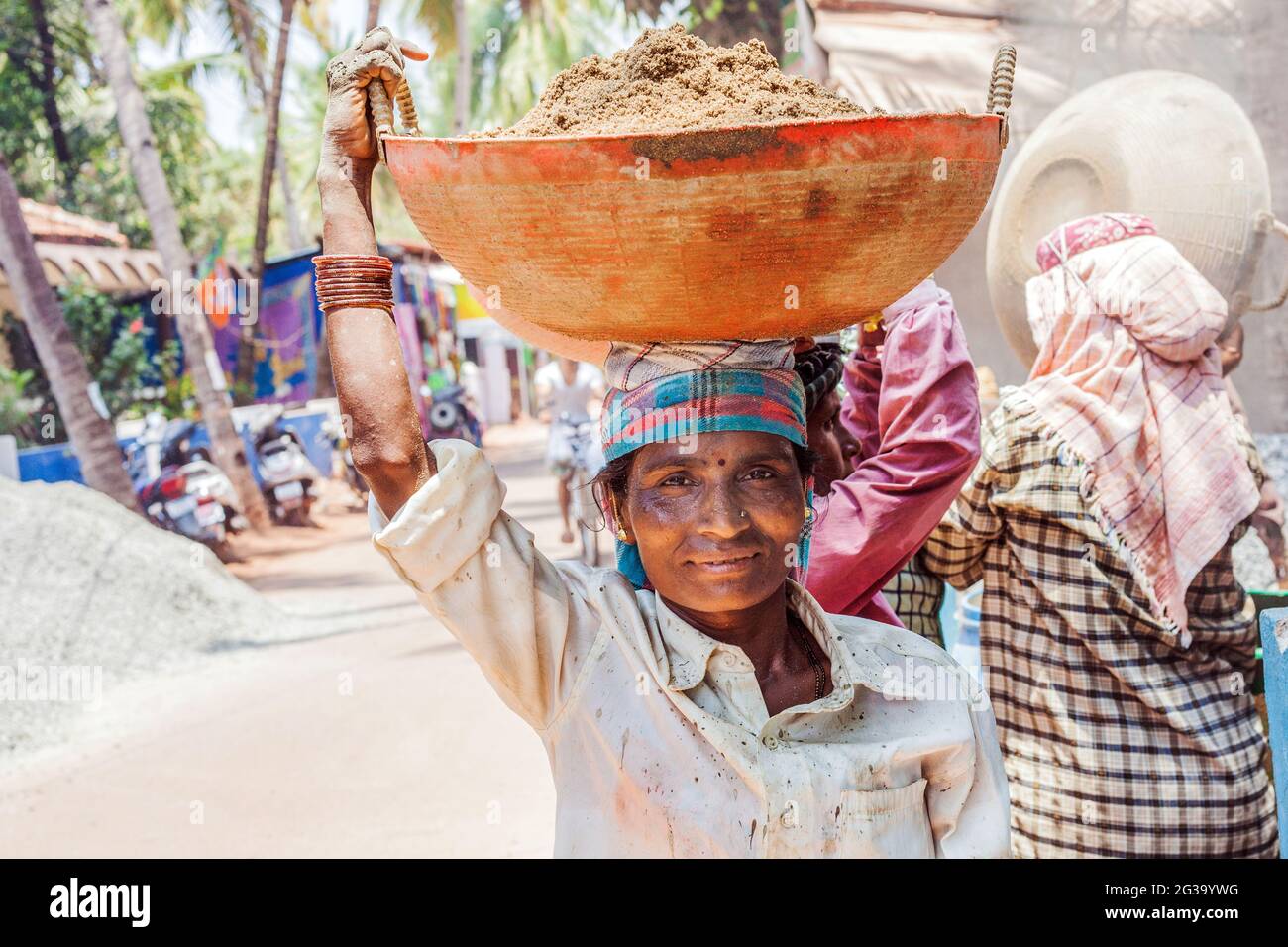 Female Indian manual labour worker carrying heavy load on her head ...