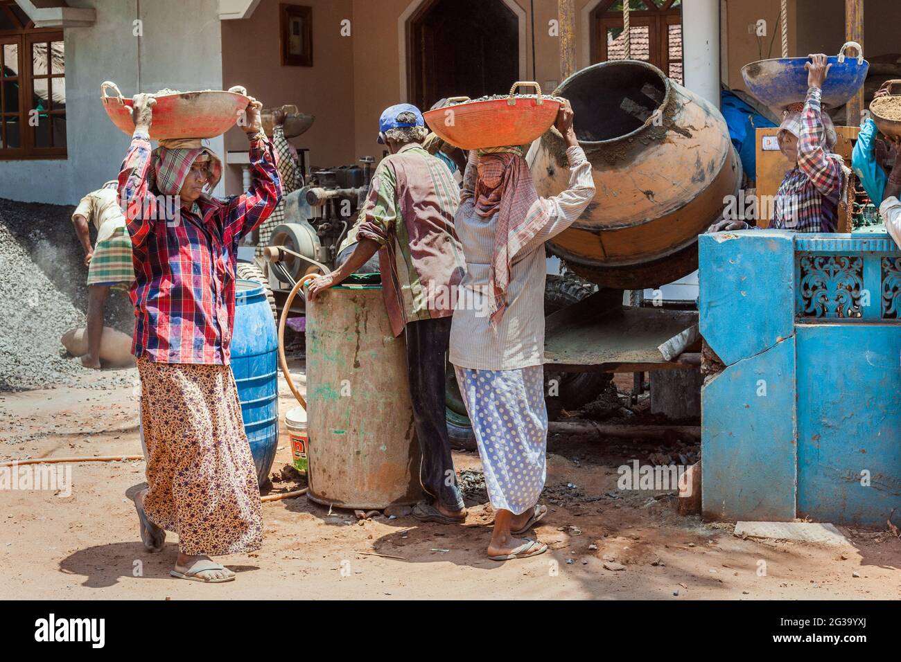 Female Indian manual labour workers carrying heavy loads on their heads ...