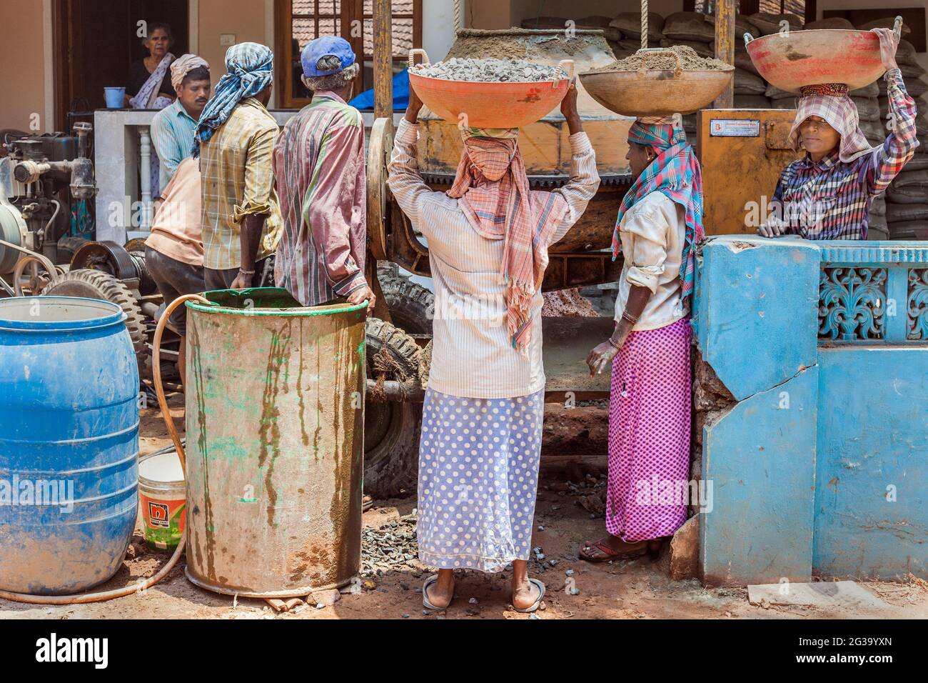 Female Indian manual labour workers carrying heavy loads on their heads ...