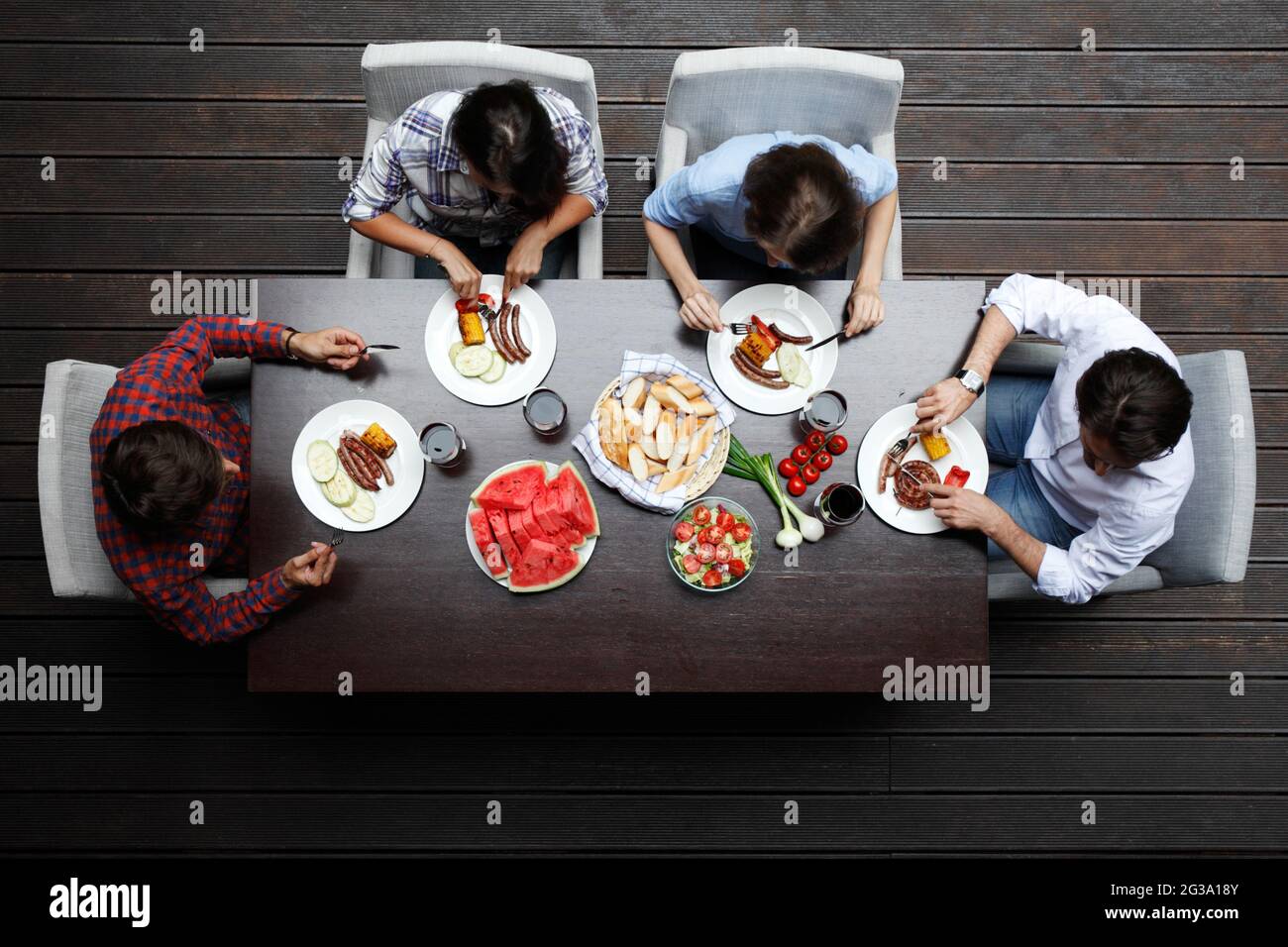 Four friends having dinner, top view Stock Photo - Alamy
