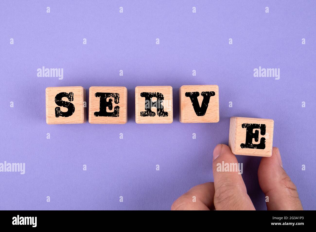 SERVE. Wooden cubes with text on a purple background Stock Photo - Alamy