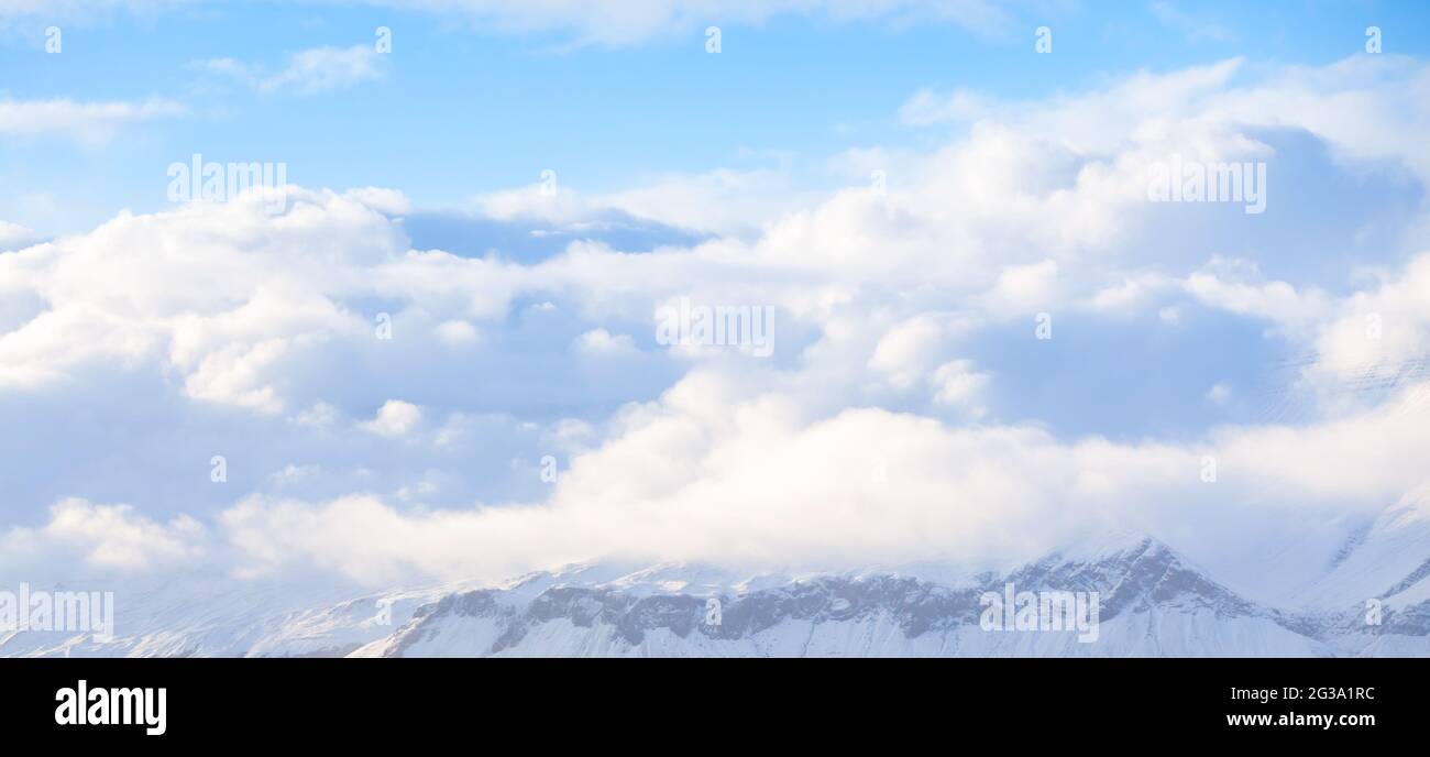 Panoramic mountain landscape with snowy peaks under white cumulus ...