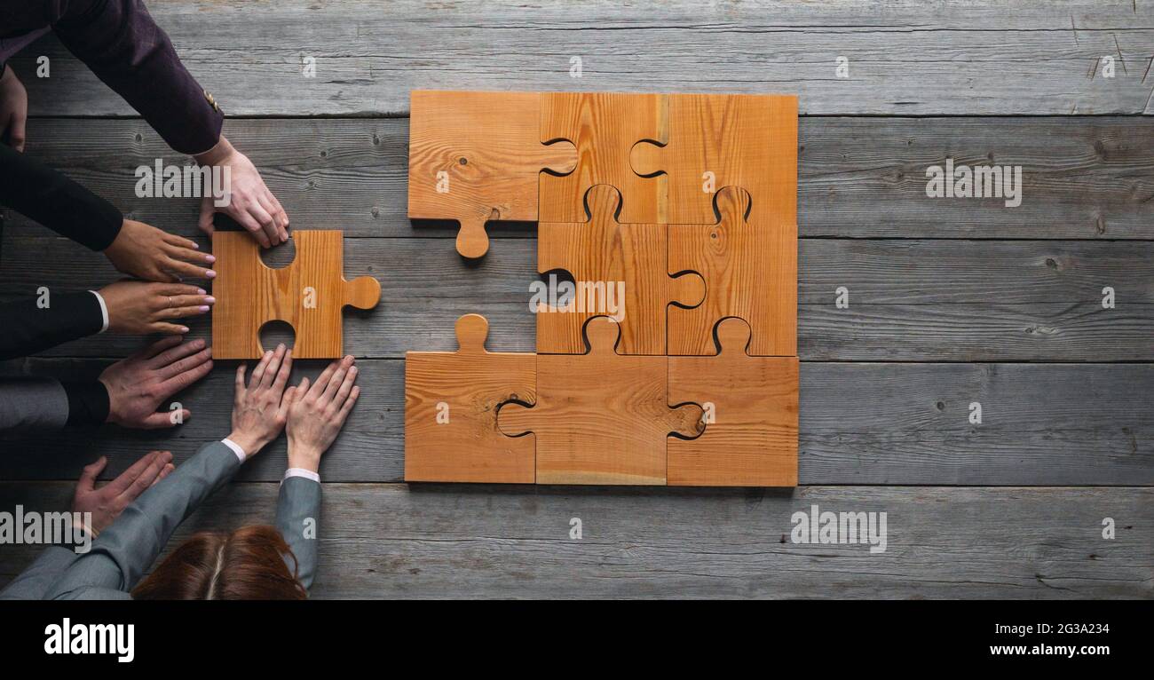 Business teamwork with puzzle finishing project cooperation unity ...