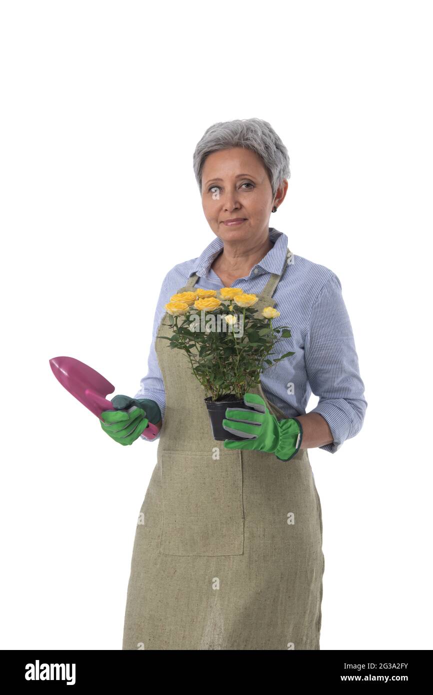 Gardening. Mature woman gardener worker with flowers in pot and scoop ...