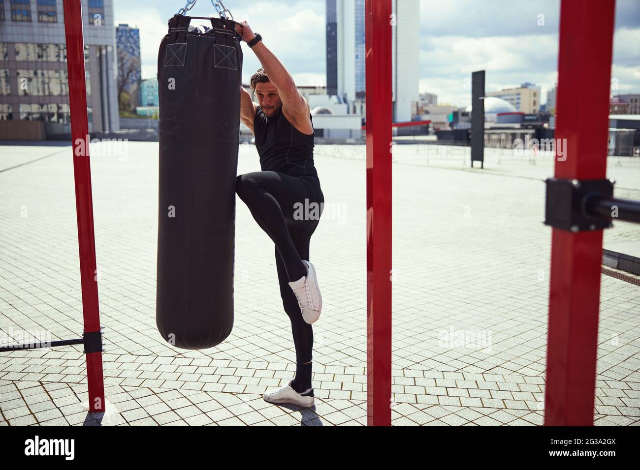 Strong male person pulling big punching bag Stock Photo - Alamy