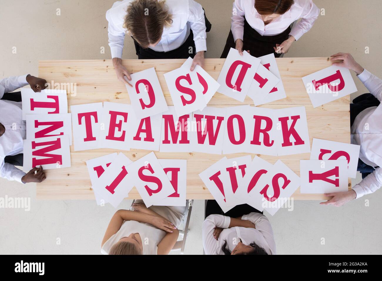 Multi-ethnic group of diverse people putting letters together teamwork ...