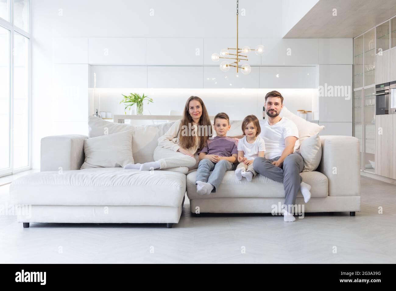 Family portrait of young parents with their two children at home, white ...