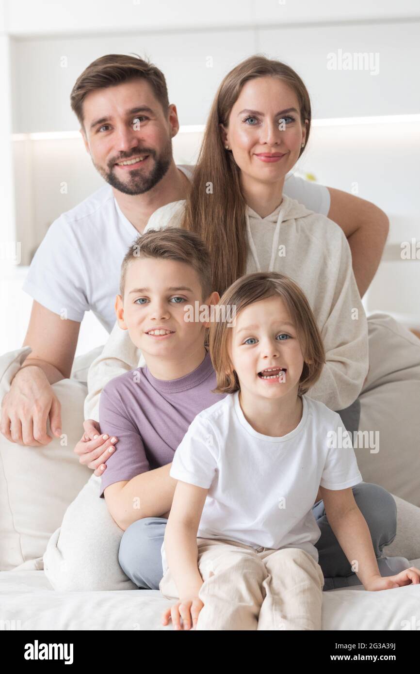 Domestic family portrait, young parents and their two children at home ...