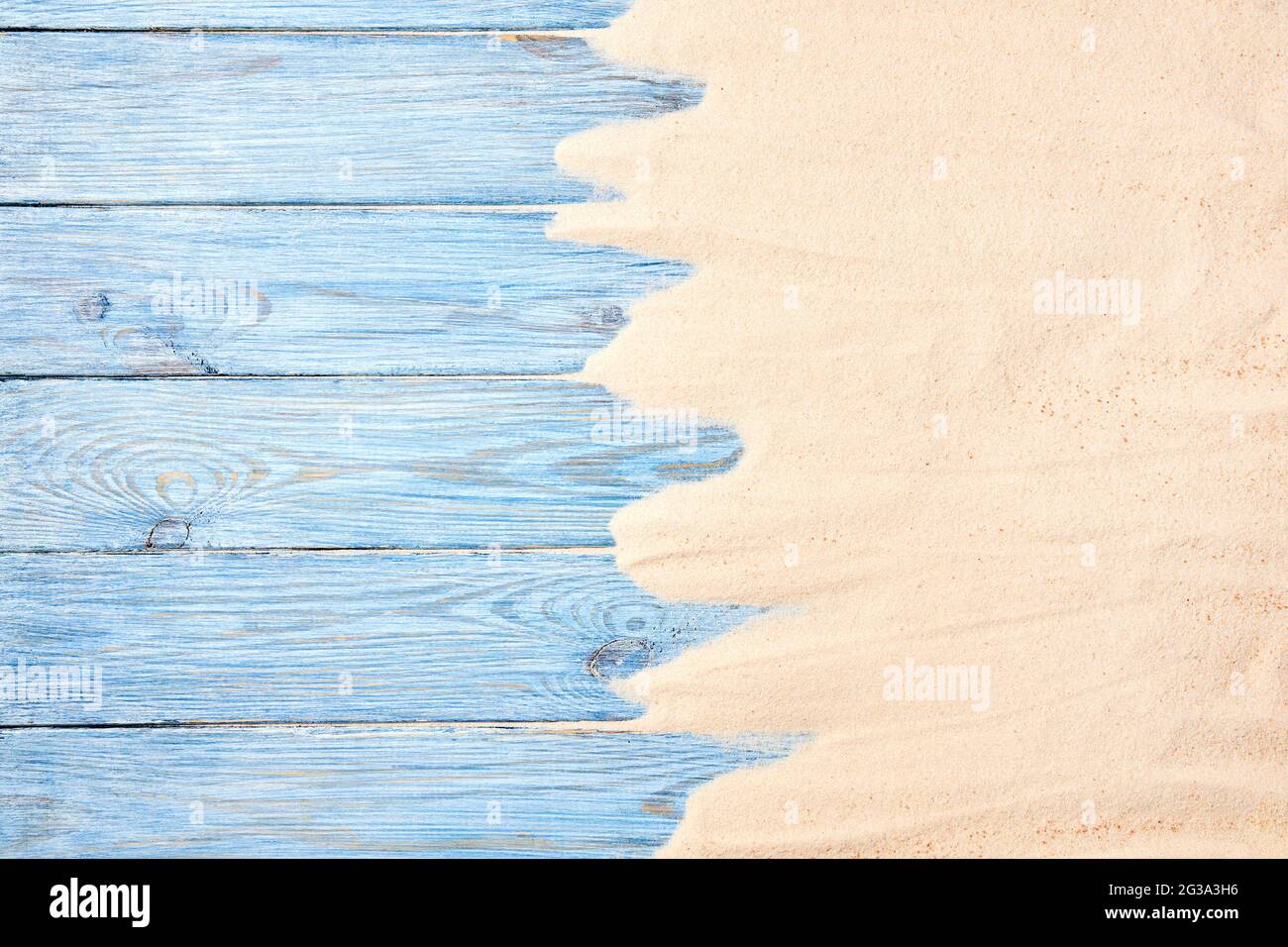 Summer background from sea sand and blue wooden planks. Top view with ...