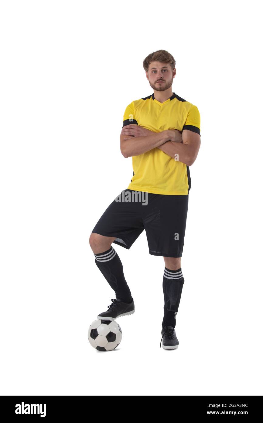 Soccer player standing with one foot on ball crossing arms isolated on ...