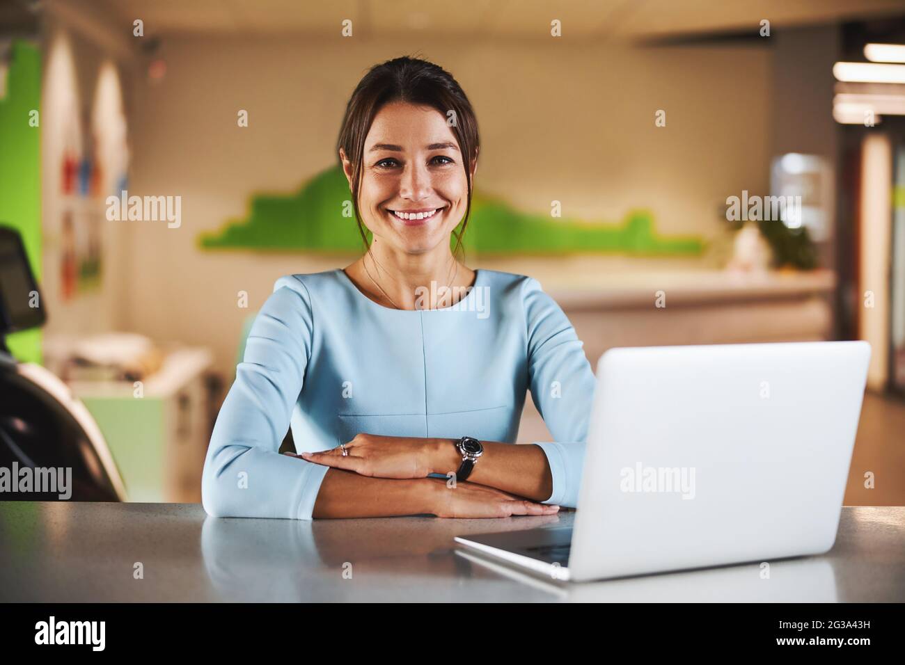 Happy attractive brunette virtual assistant working at the laptop in ...