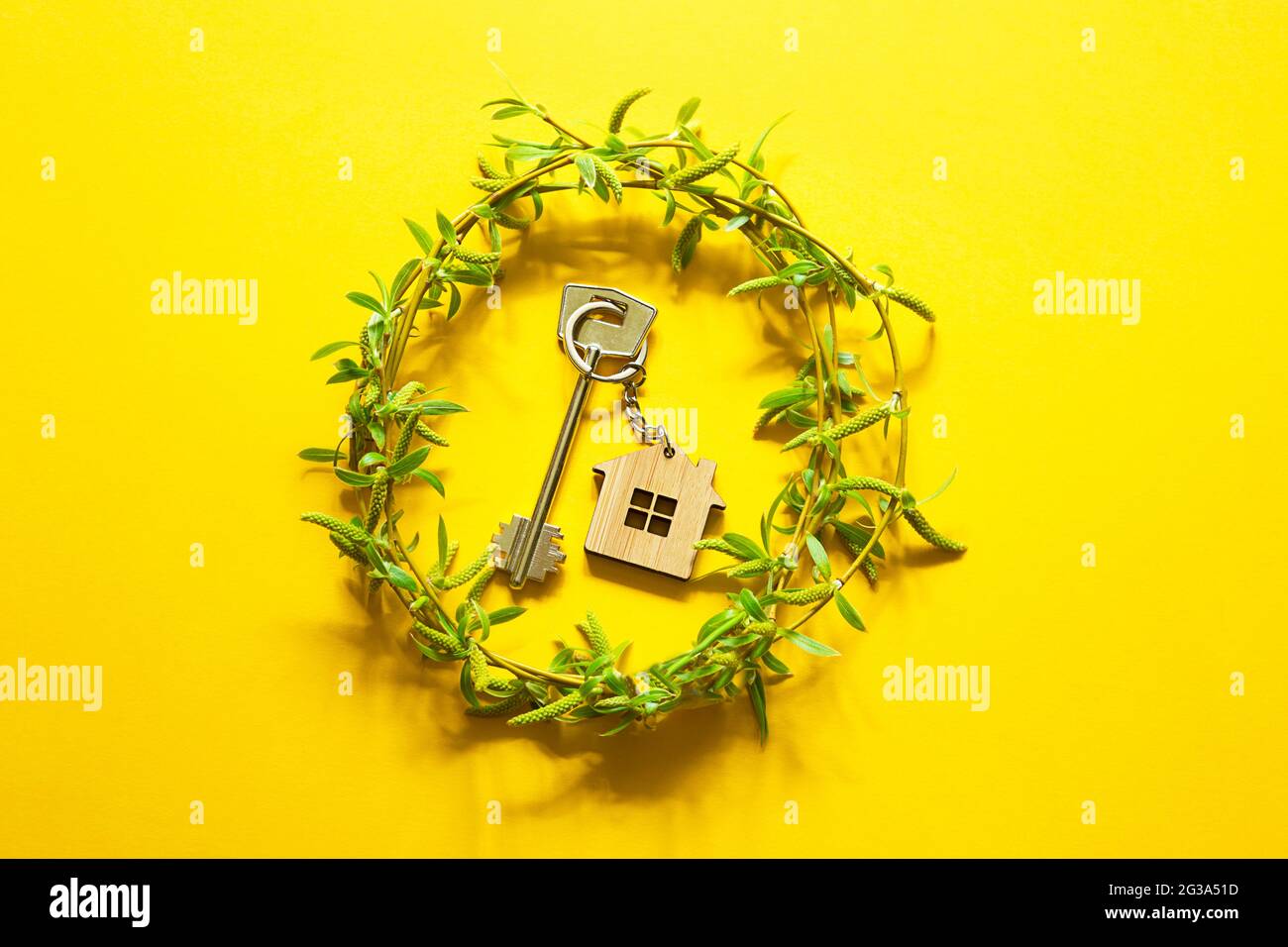 House key with keychain on yellow background and spring bouquet of ...