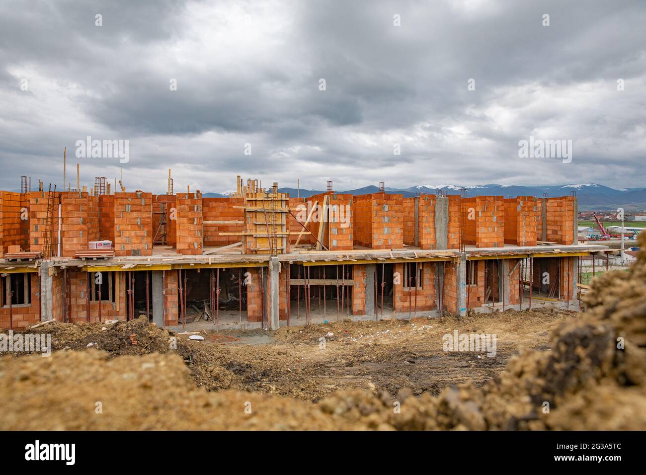 Outdoor construction site with unfinished orange building under a ...