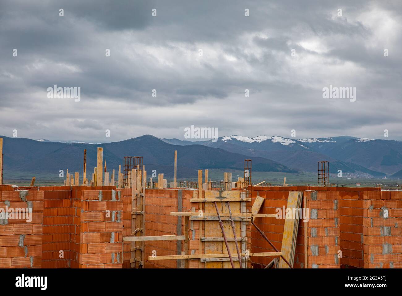 Outdoor construction site with unfinished orange building under a ...