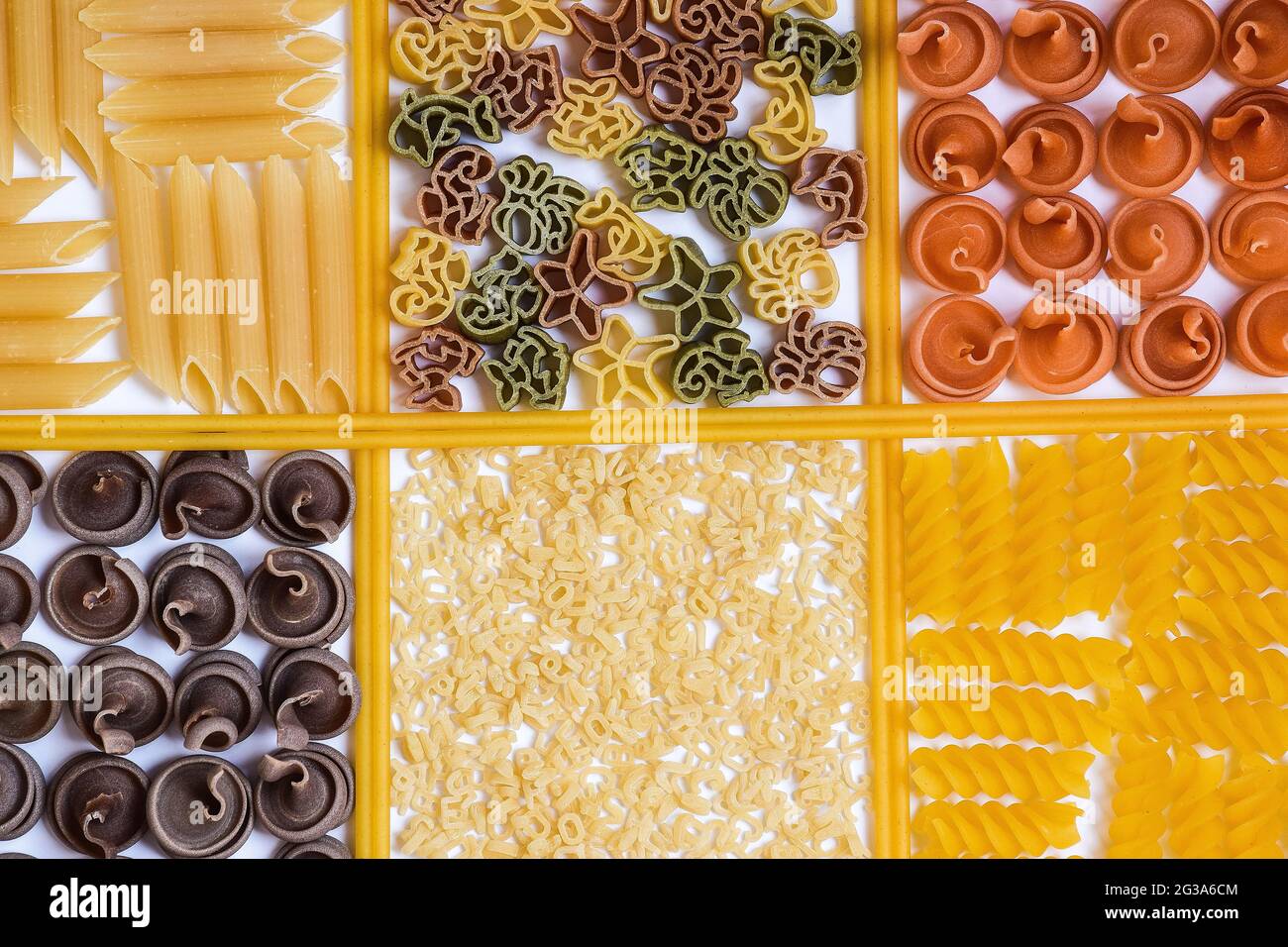 Raw pasta and spaghetti of different colors and types are laid out in ...