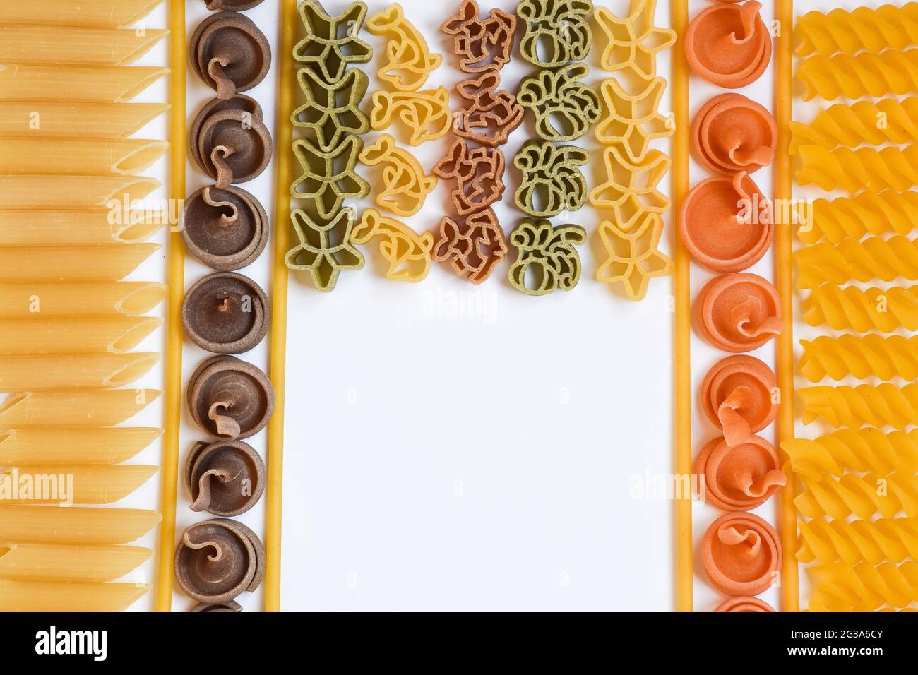 Raw pasta and spaghetti of different colors and types are laid out ...