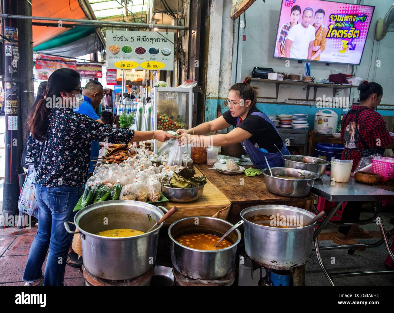 The lunch rush begins at this robust street food eatery as customers ...