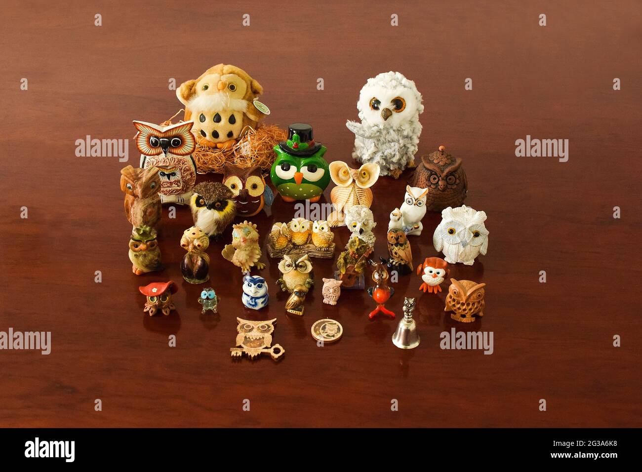 Toy figurines of owls of different shapes and sizes on a wooden table ...