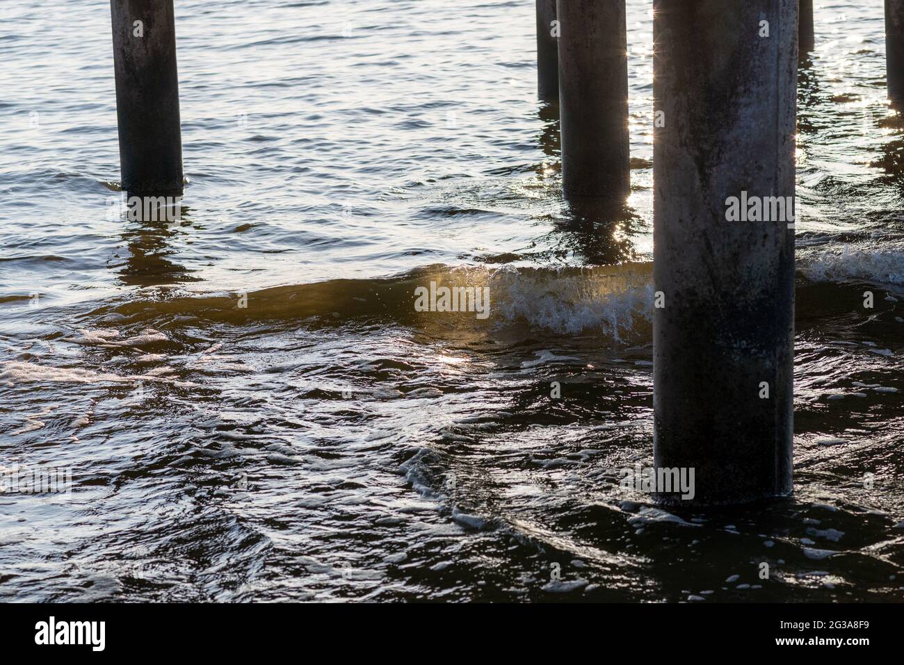 Columnar bridge piers at sunset.View under the bridge into sea with ...