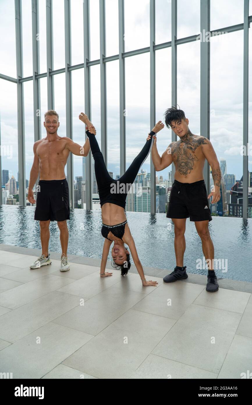 2 men pick up girl play gymnastics Stock Photo - Alamy