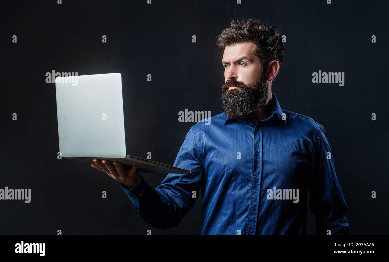 Holding laptop computer. Serious handsome bearded man worker laptop ...