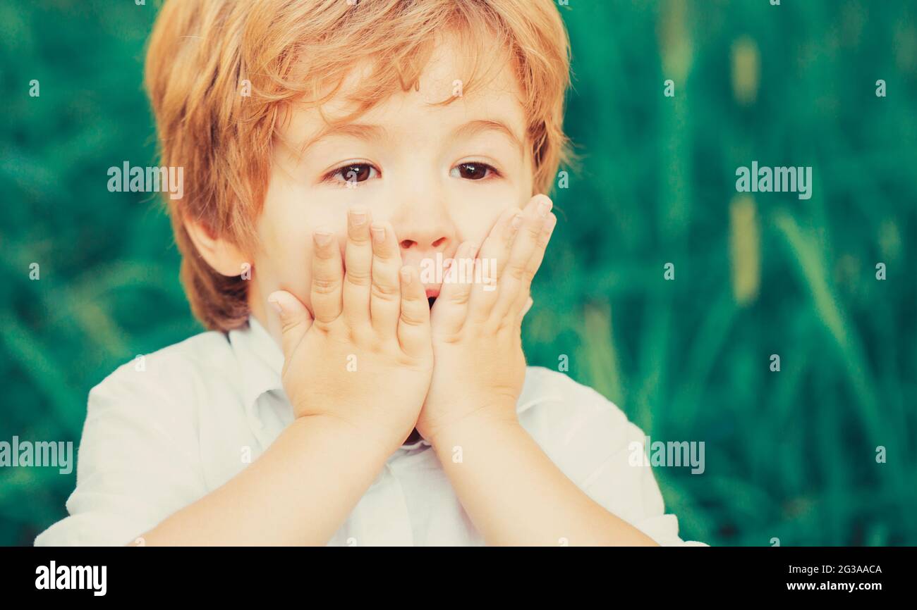 Child expressing surprise with his hands in his face. Smiling amazed or ...