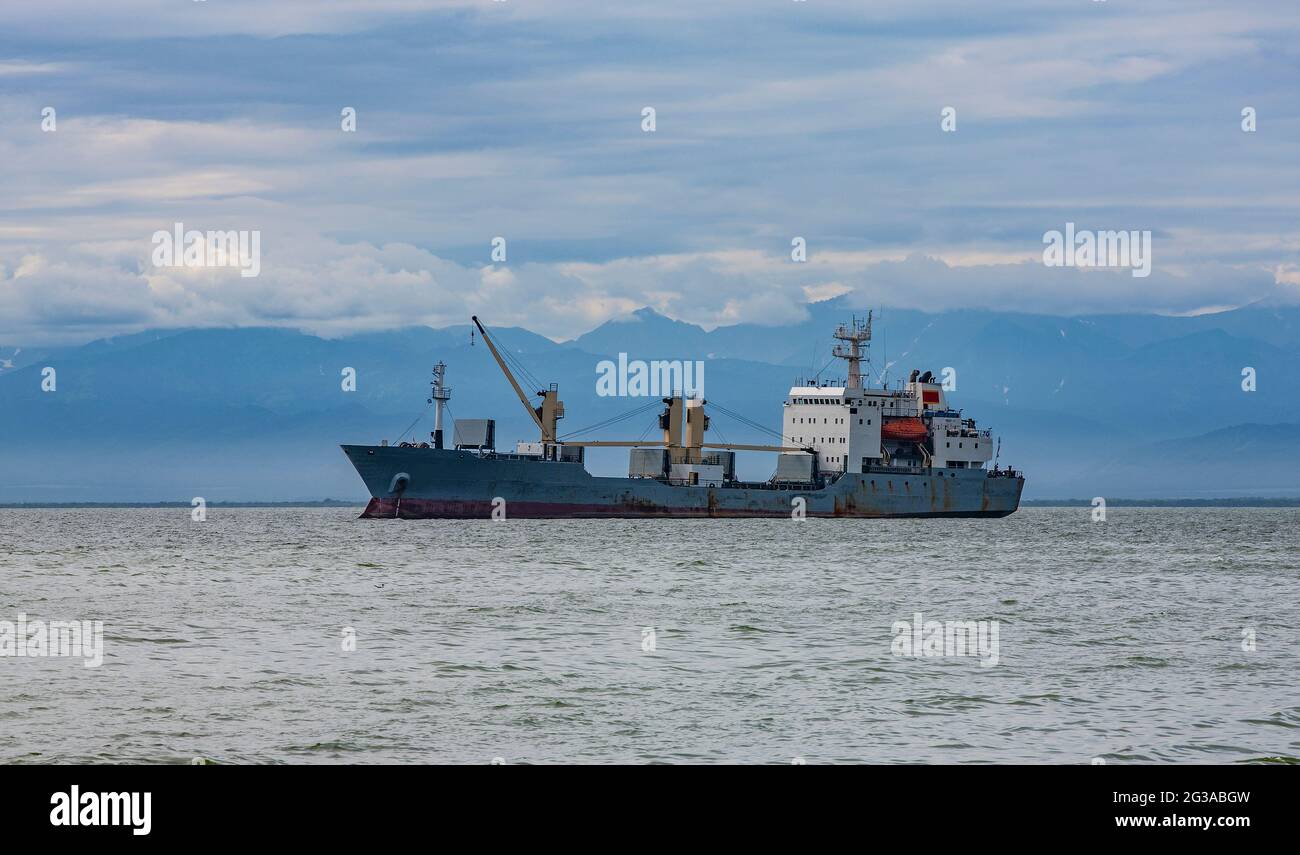 Large cargo container ship sailing against the volcano Stock Photo - Alamy