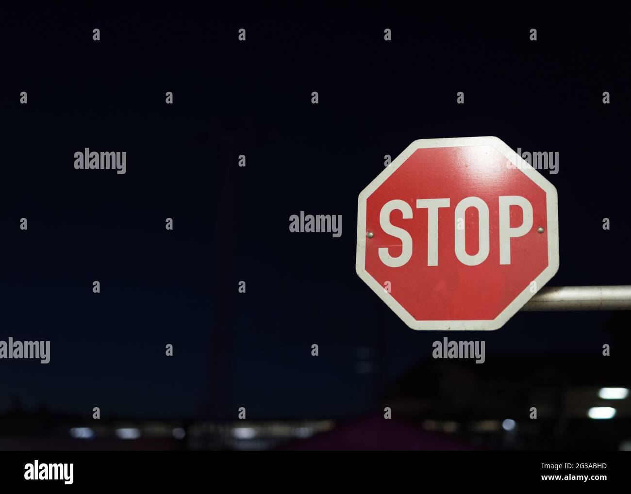 Stop sign brightly lit at night in the city Stock Photo - Alamy