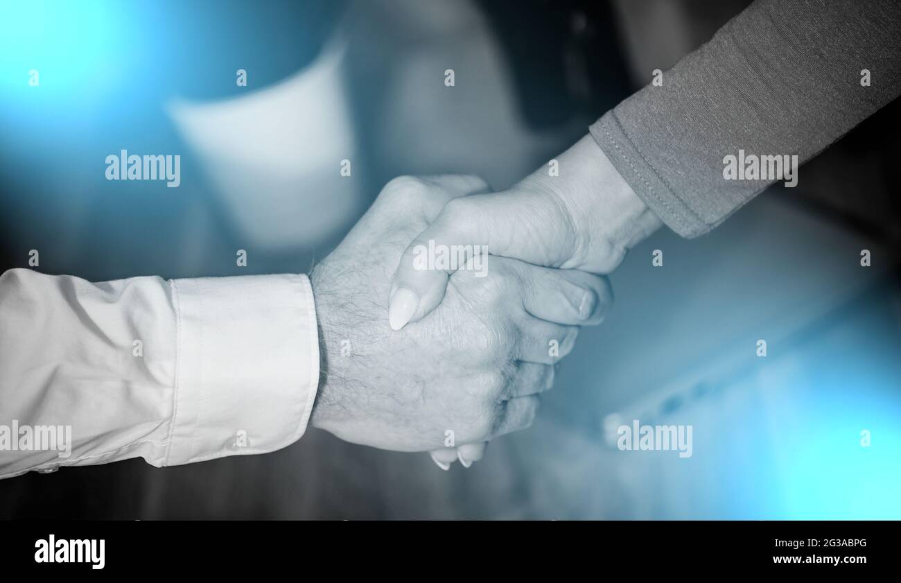 Businesswoman and businessman shaking hands; light effect Stock Photo ...