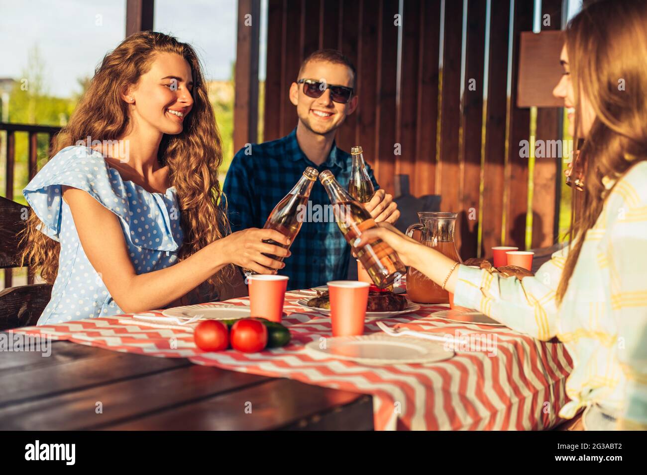 Young friends are having fun, drinking drinks at home dinner outdoors ...