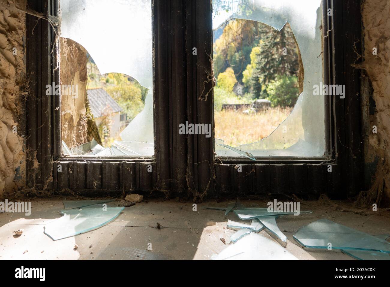 Old broken dirty window on an old wall with cracked plaster and peeling ... Old broken dirty window on an old wall with cracked plaster and peeling ...