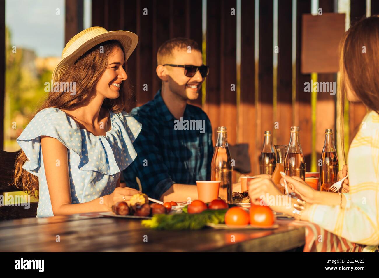 Young people have fun on the terrace, drink drinks and chat while their ...