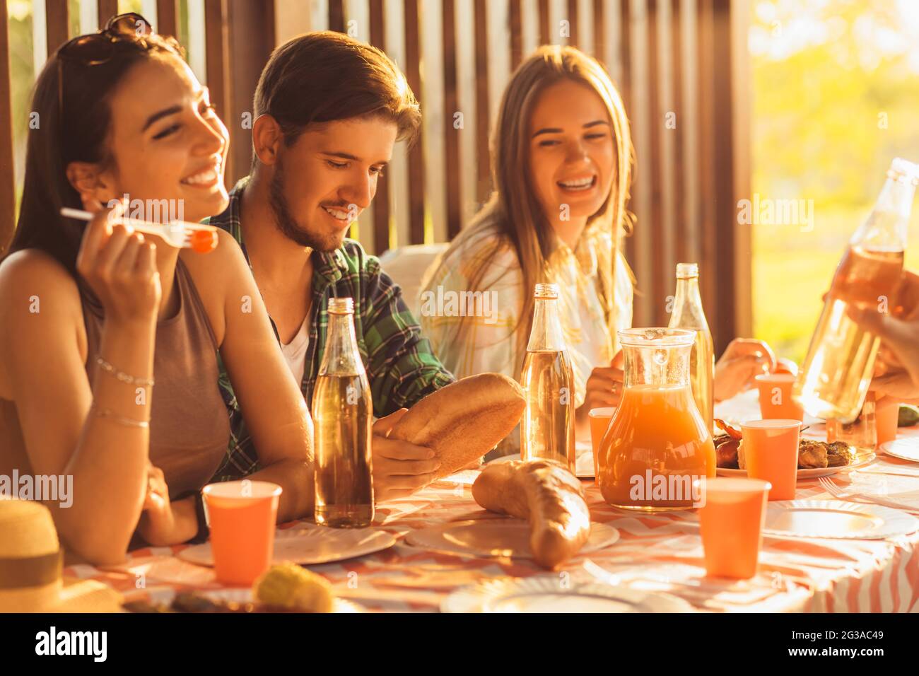 company of young friends are sitting at the table, drinking beer drinks ...