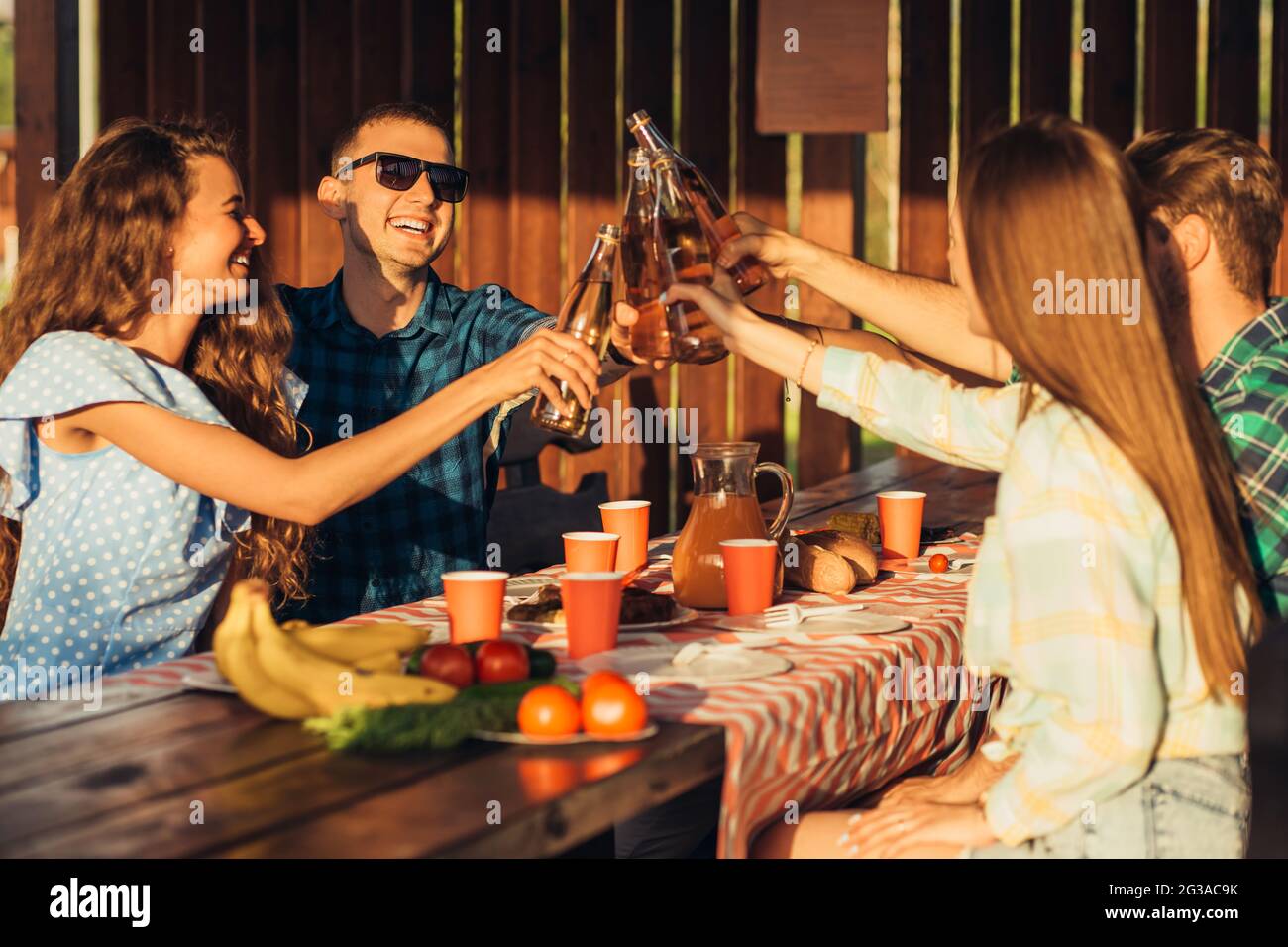 Group of happy young friends having lunch outdoors, friends celebrate ...