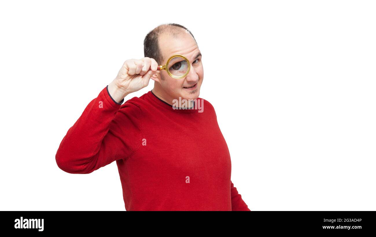 A bald young man wearing a red sweater is looking forward through a ...