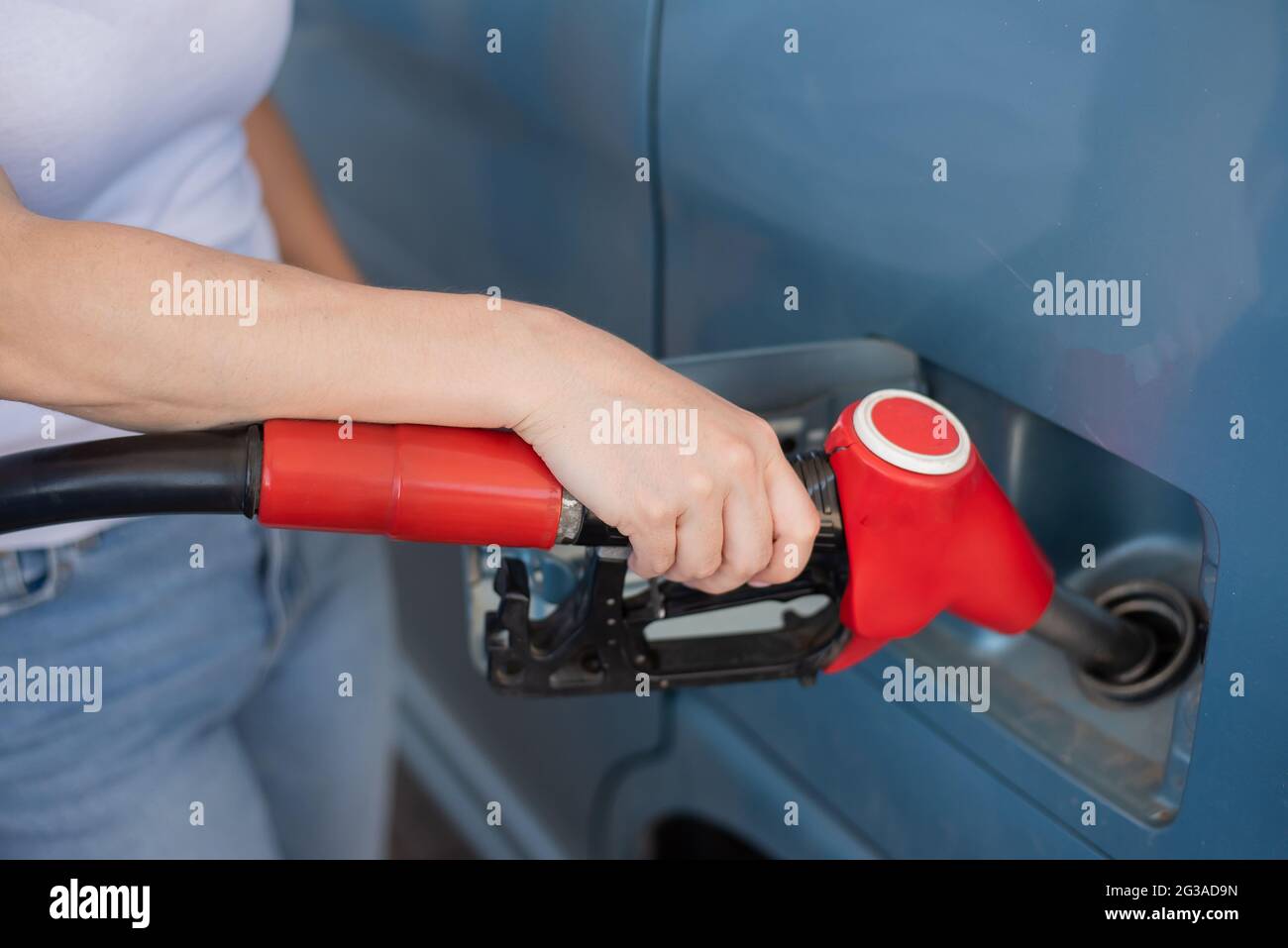 Caucasian woman refueling a car at a self-service gas station Stock ...