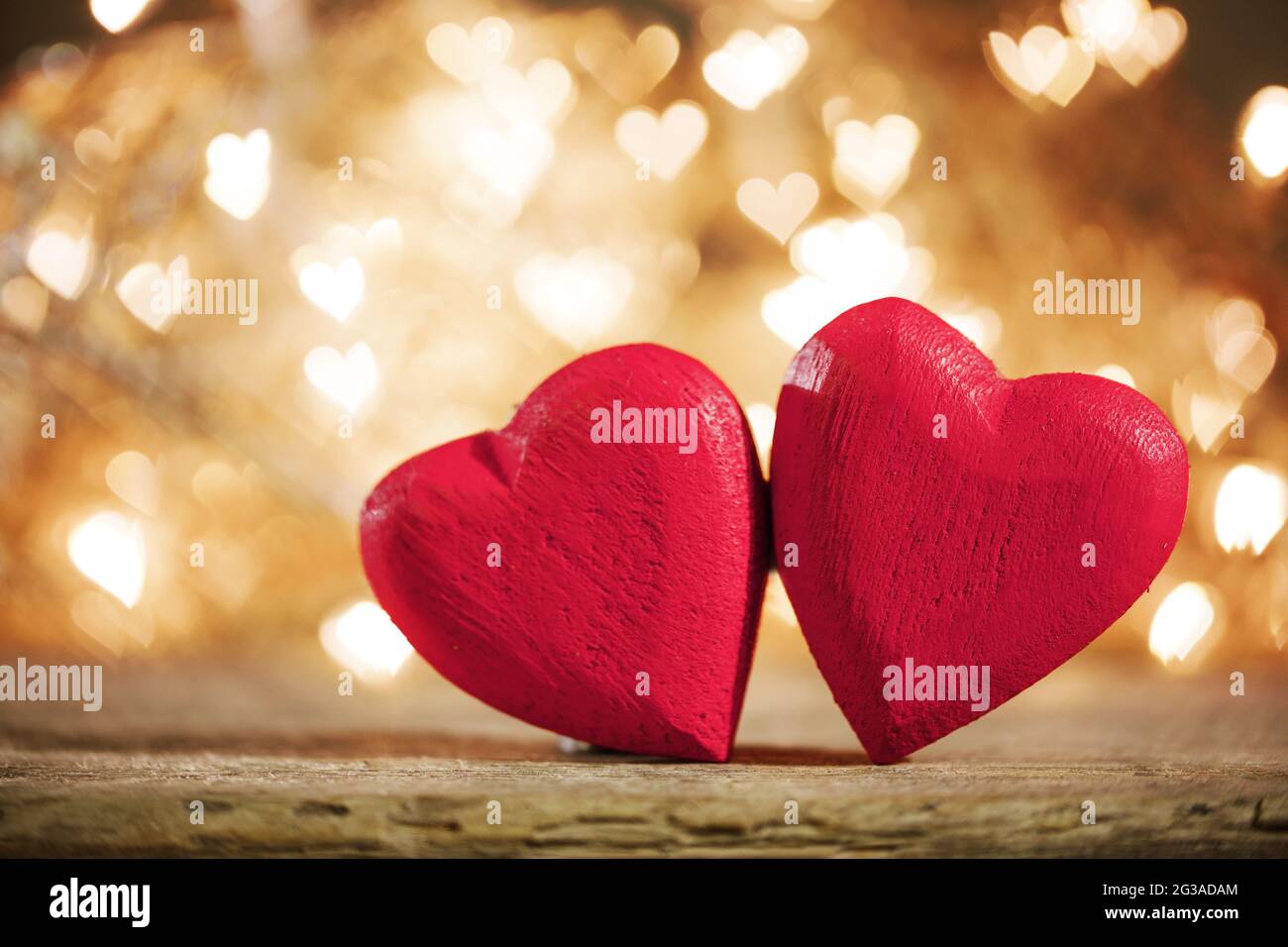 Two red wooden hearts symbol of love on background with beautiful bokeh ...