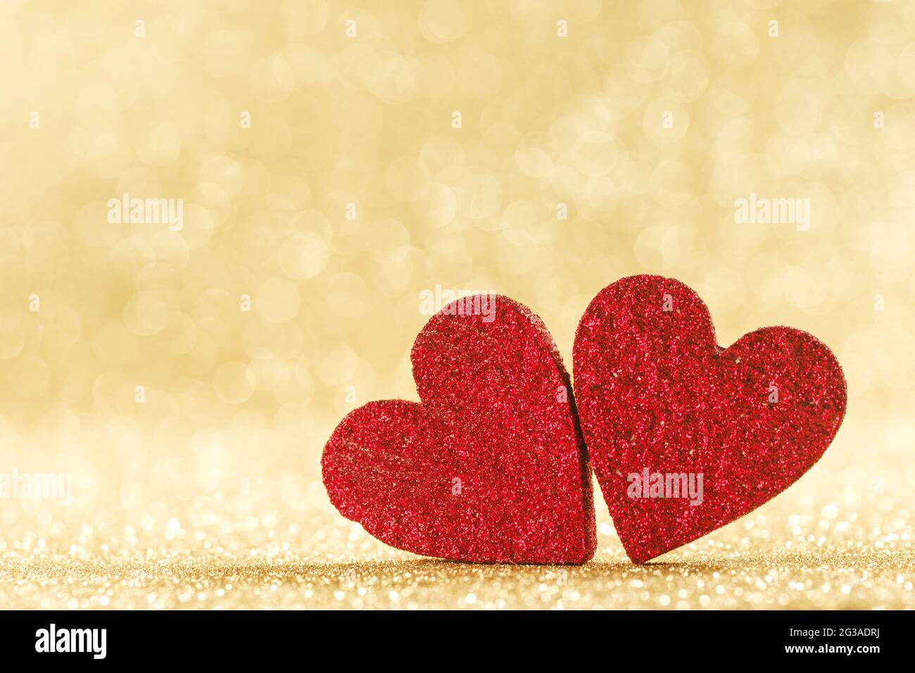 Two red hearts symbol of love on golden background with beautiful bokeh ...