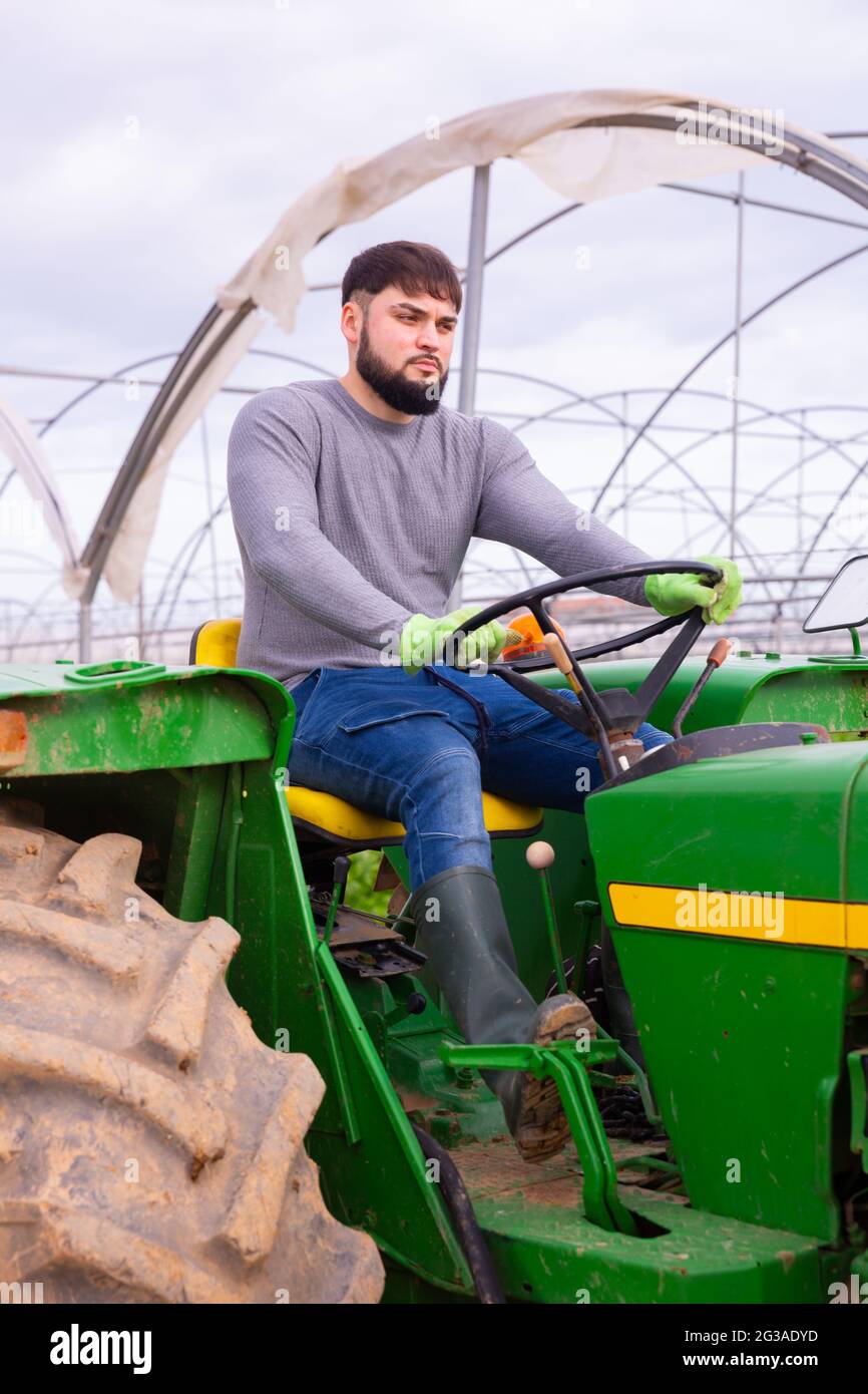Guy driving farm tractor Stock Photo - Alamy