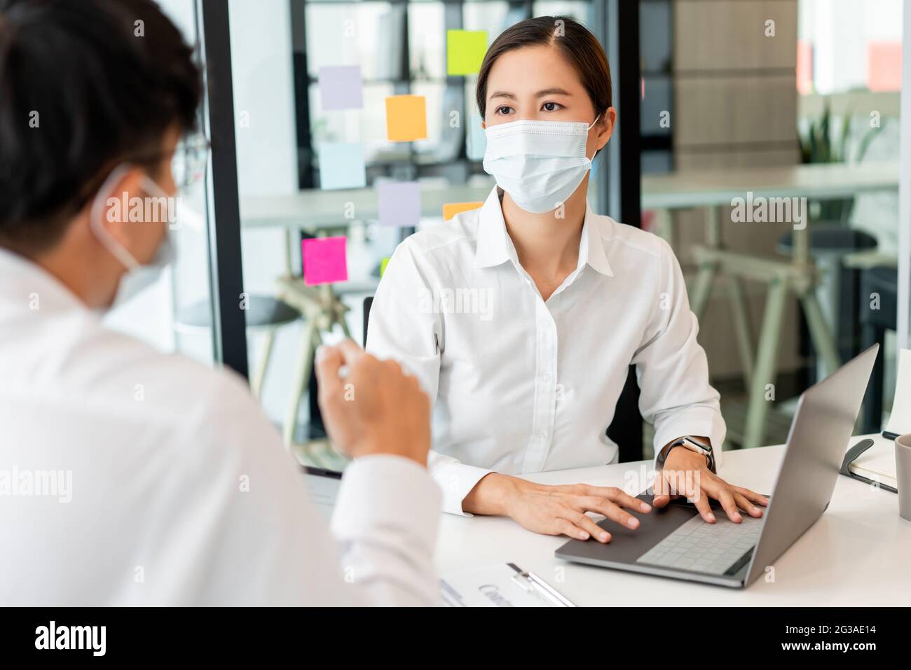 two coworkers helping each other to revise the contract before signing ...